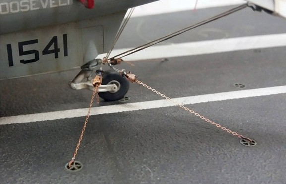 Carrier-based helicopter tie down chain assemblies